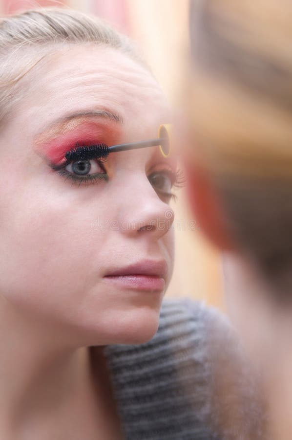 Woman applying makeup stock photo. Image of caucasian - 145128682