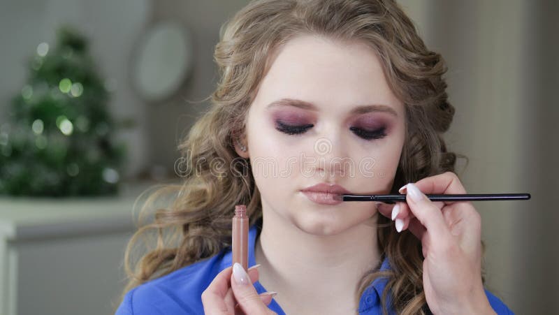 Applying Makeup. the Model`s Lips are Painted with a Makeup Brush ...