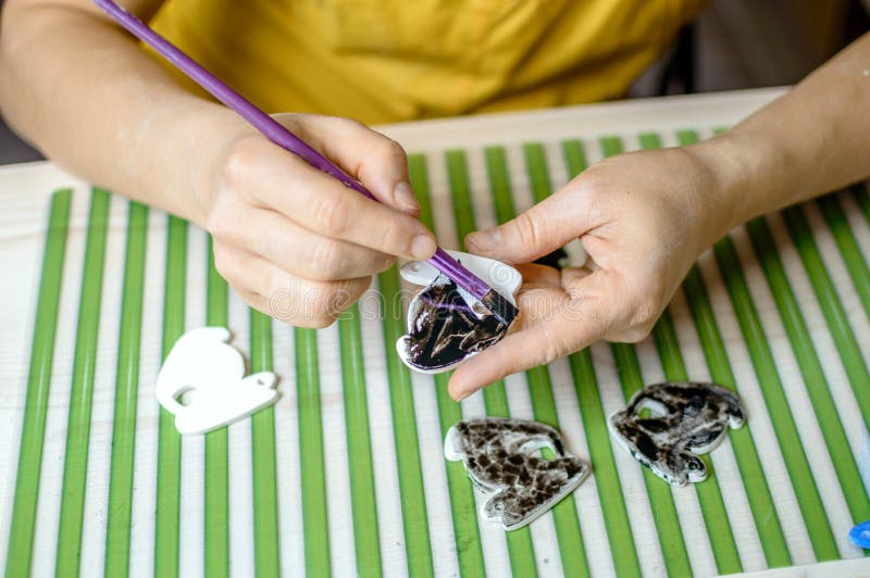 Applying Paint To a Clay Keychain with a Brush Stock Image - Image of ...