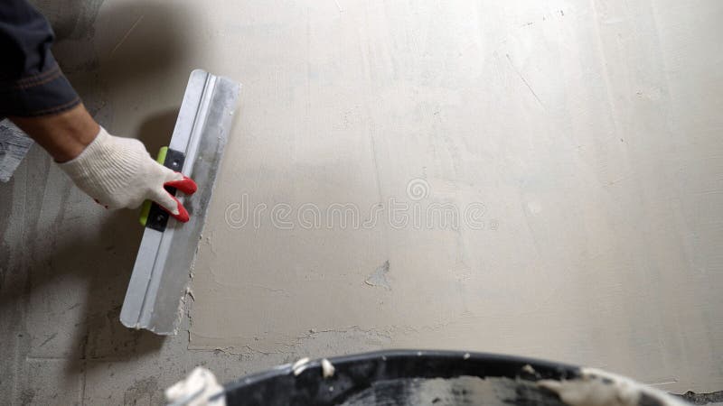 Applying Plaster To the Wall Using a Long Spatula. Construction Tool at ...
