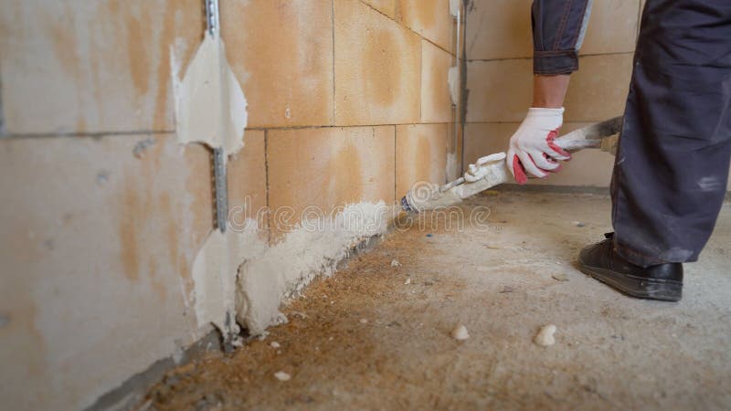 A Worker Sprays Putty on a Wall. the Process of Applying Plaster To ...