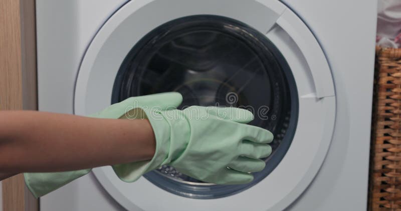 Applying Rubber Gloves Against the Backdrop of a Washing Machine Stock ...