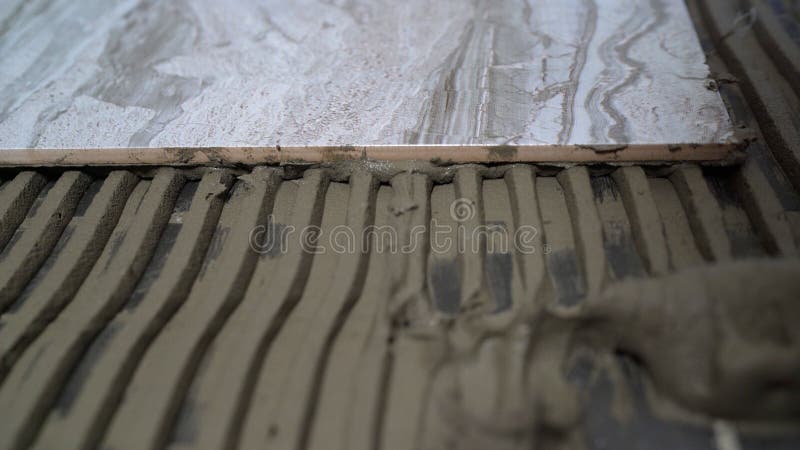 The Process of Laying Ceramic Floor Tiles. Spreading Wet Mortar before ...