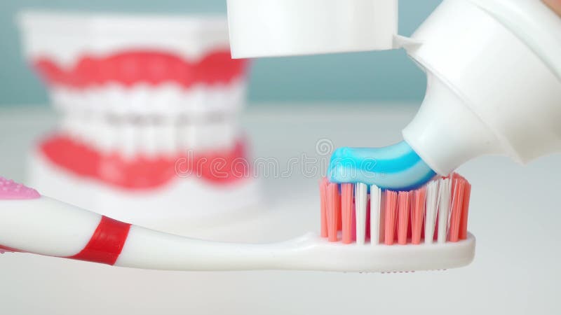 Applying Vibrant Blue Toothpaste on Toothbrush with Teeth Model in ...