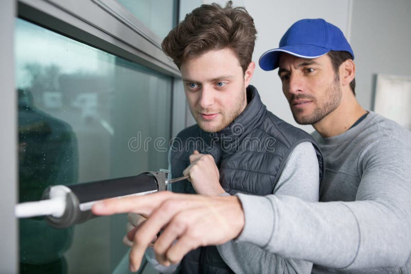 Apprentice Being Advised How To Apply Caulk To Window Stock Image ...