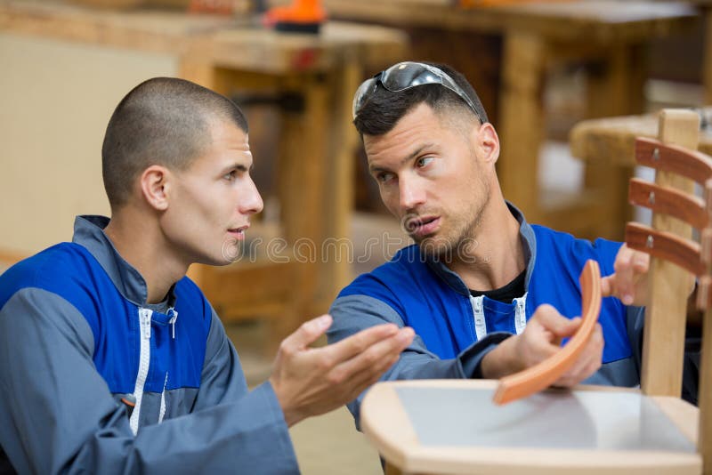Apprentice Carpenter Discussing Broken Chair with Supervisor Stock ...
