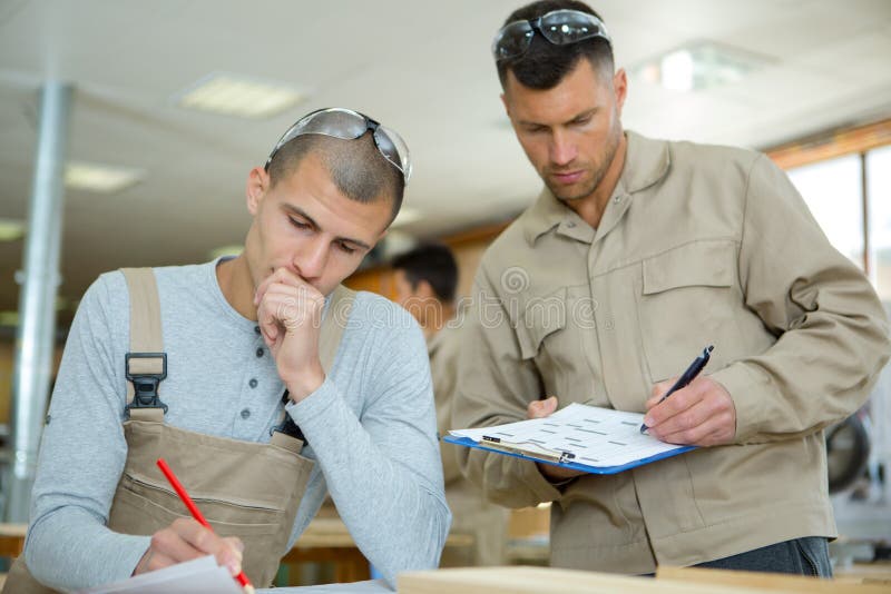 Apprentice Carpenter Taking Notes with Tutor Stock Image - Image of ...