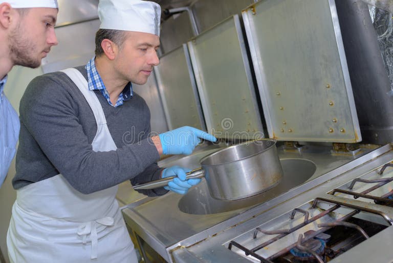 Apprentice and Chief Preparing Meat in Restaurant Kitchen Stock Photo ...