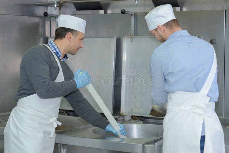 Apprentice and Chief Preparing Meat in Restaurant Kitchen Stock Photo ...