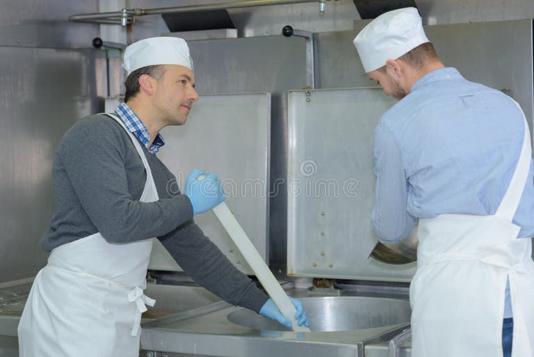 Apprentice and Chief Preparing Meat in Restaurant Kitchen Stock Photo ...