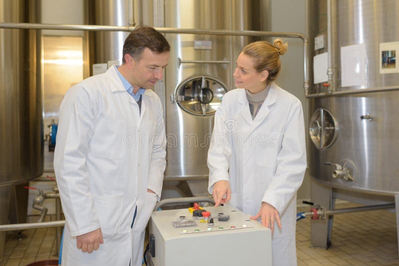 Apprentice and Engineer Using Computer Controlled Machine Stock Photo ...