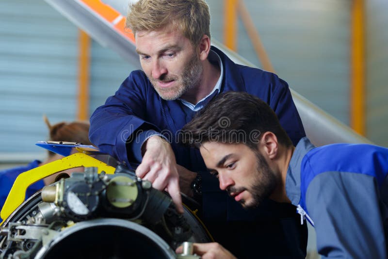 Apprentice Mechanic Working Under Supervision Stock Photo - Image of ...