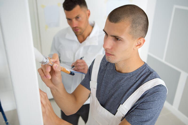 Apprentice Painter and Decorator Using Masking Tape Stock Image - Image ...