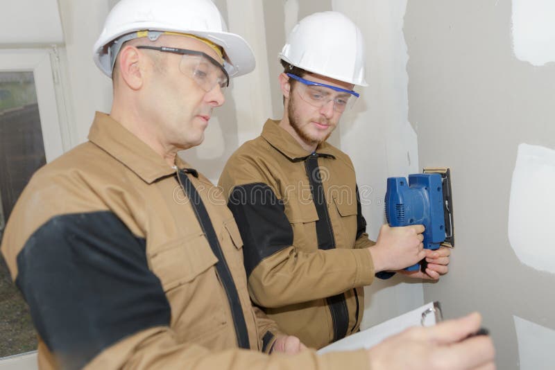 Apprentice Plasterer Sanding Wall Stock Photo - Image of hardhat ...