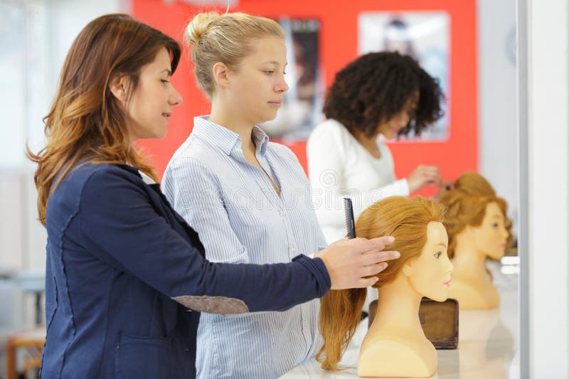 Apprentice Practicing in Beauty School with Beautician Model Heads ...