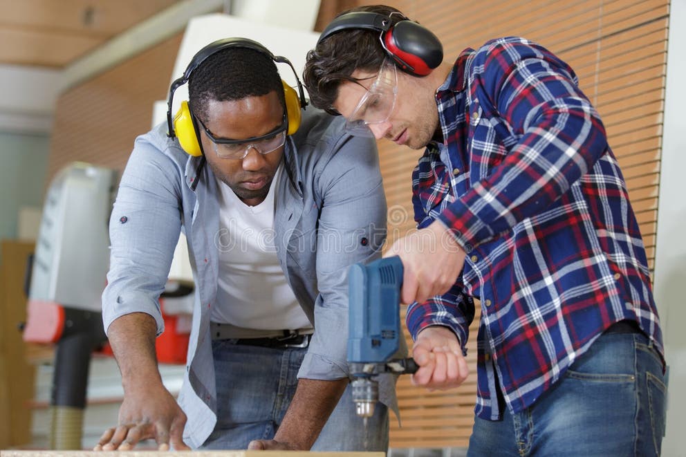 Apprentice Watching Foreman Use Electric Drill Stock Photo - Image of ...