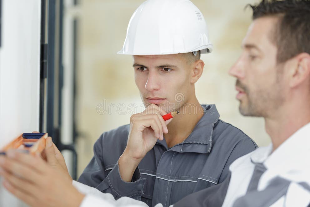 Apprentice Watching Foreman Use Spirit Level Stock Photo - Image of ...