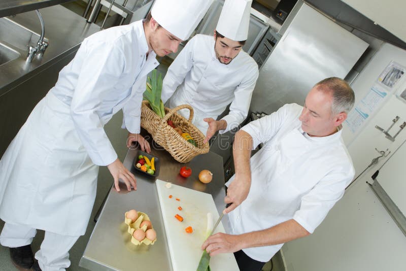 Apprentices and Experienced Chef Cooking Together Stock Photo - Image ...