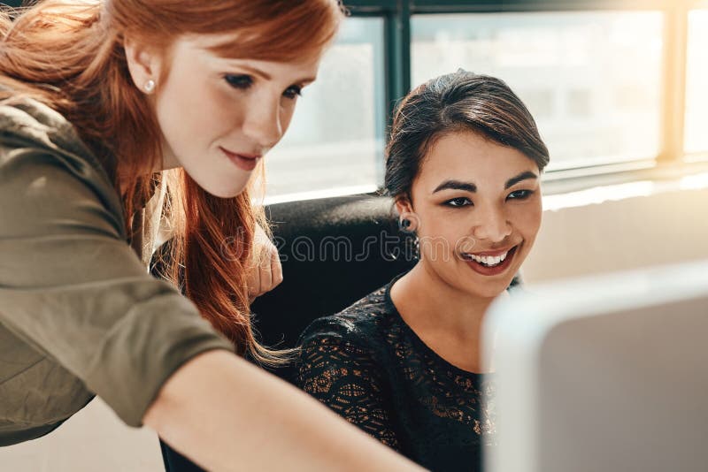 Approaching a Task a Team. Two Young Businesswomen Using a Computer ...