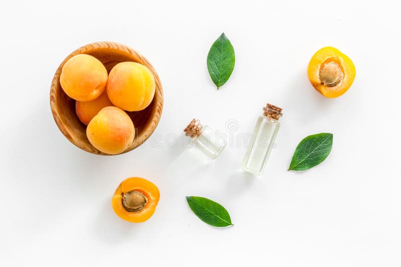 Apricot Kernel Oil among Apricots and Leaves on White Background Top ...