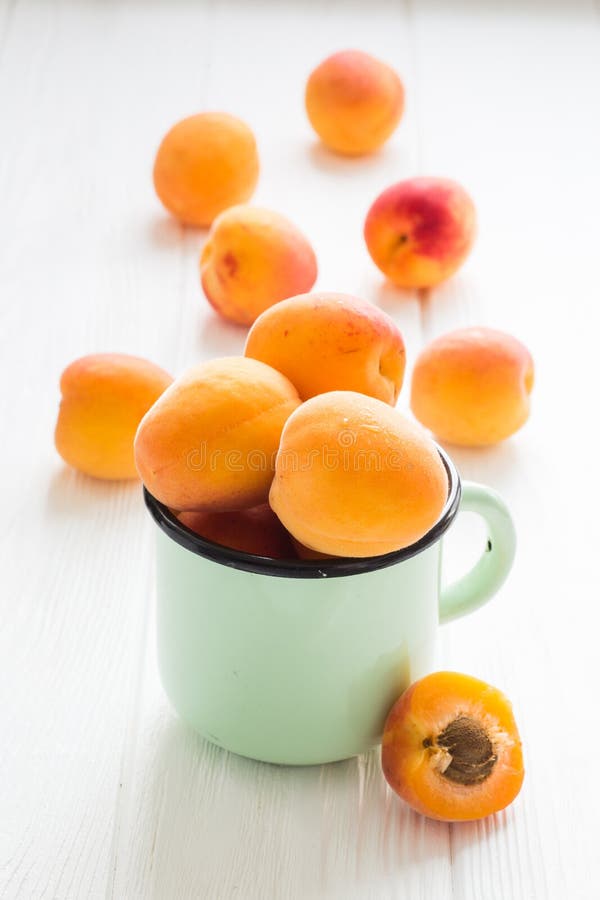 Apricot in Tea Cup on a White Wooden Table Stock Photo - Image of close ...