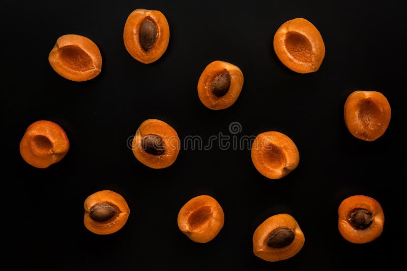 Apricots Cut into Halves Lie on a Black Background, Top View Stock ...