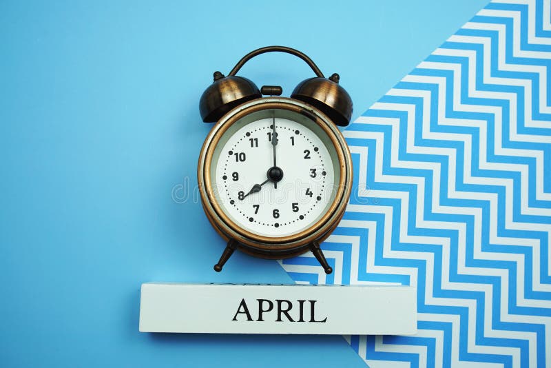 April and Alarm Clock on Blue Background Stock Photo - Image of color ...