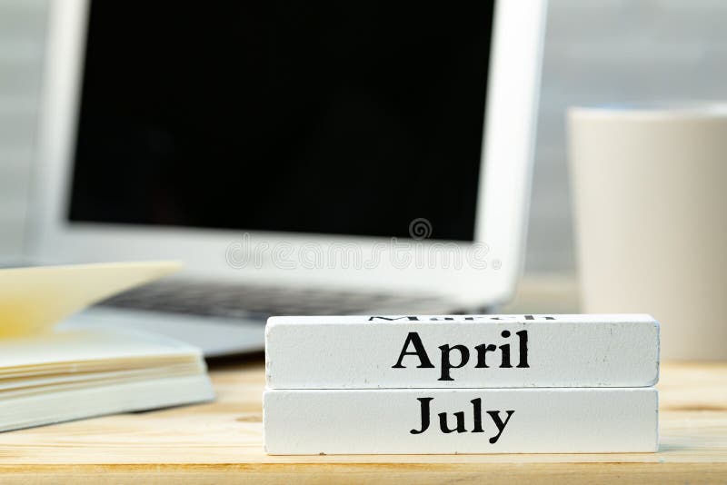 April and July Wooden Blocks on Working Table with Open Laptop Stock ...