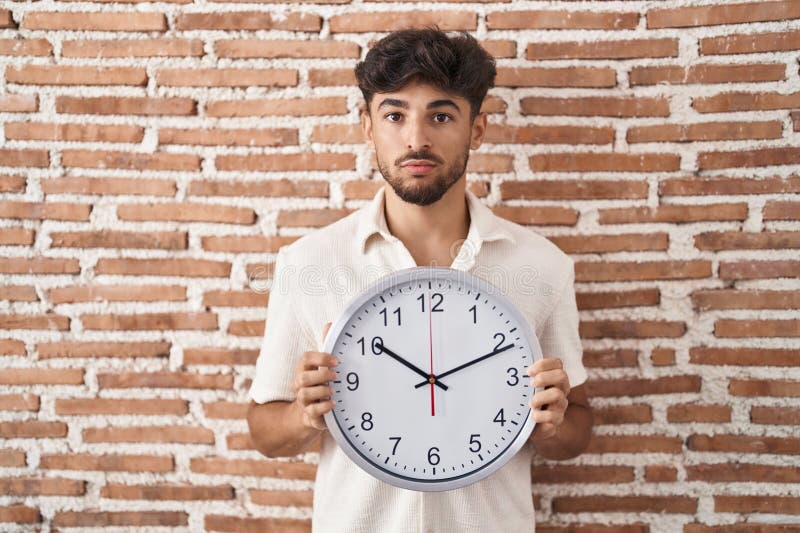 Arab Man with Beard Holding Big Clock Relaxed with Serious Expression ...
