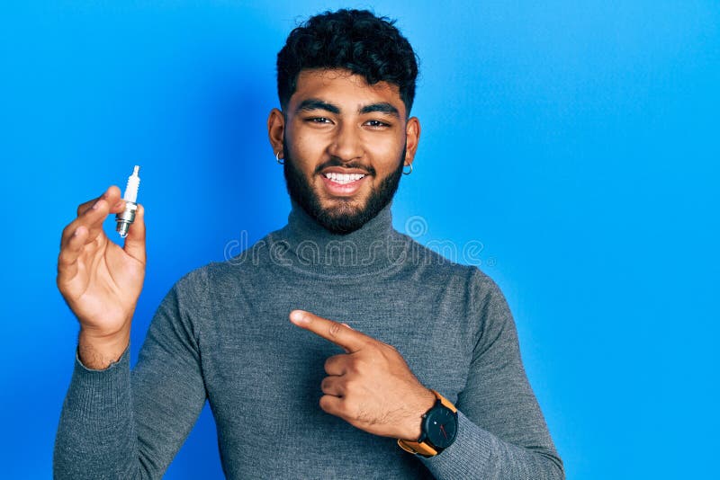 Arab Man with Beard Holding Spark Plug Smiling Happy Pointing with Hand ...