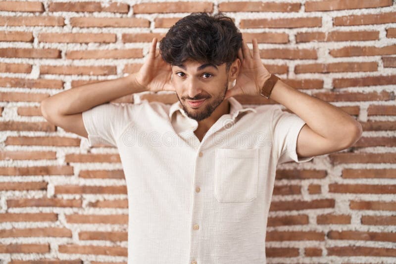 Arab Man with Beard Standing Over Bricks Wall Background Doing Bunny ...