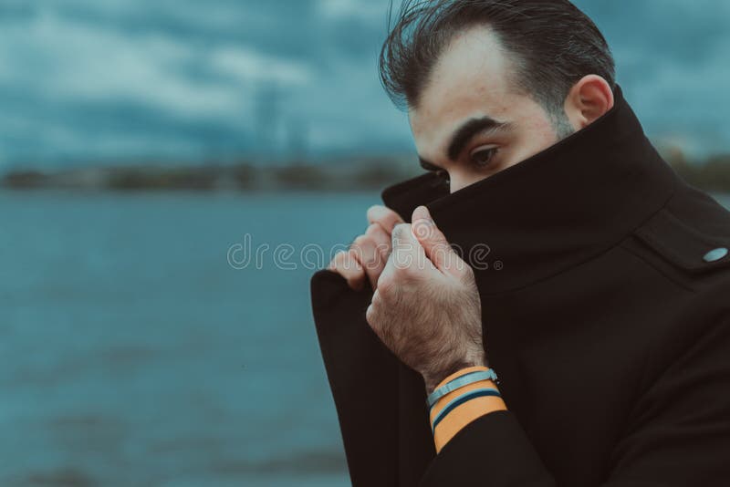An Arab Man Covers Half His Face with the Collar of His Jacket. Stock ...