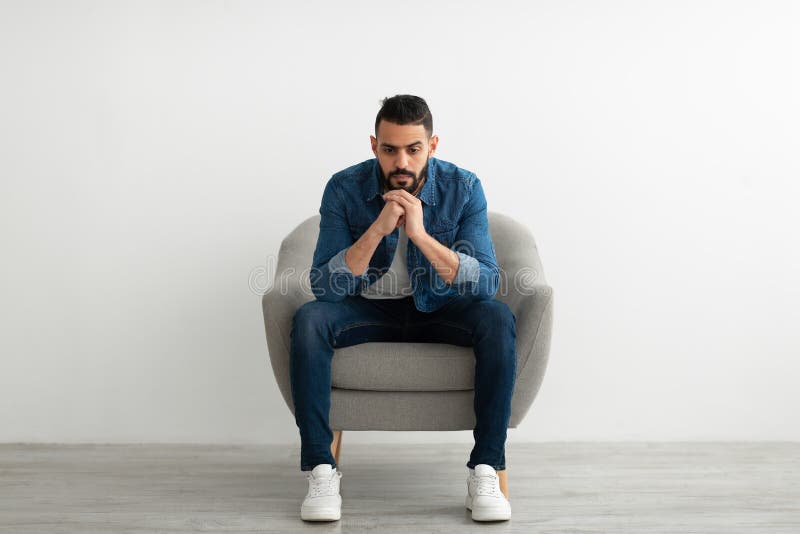 Arab Man Sitting in Armchair with Dull Face Expression, Feeling Sad or ...