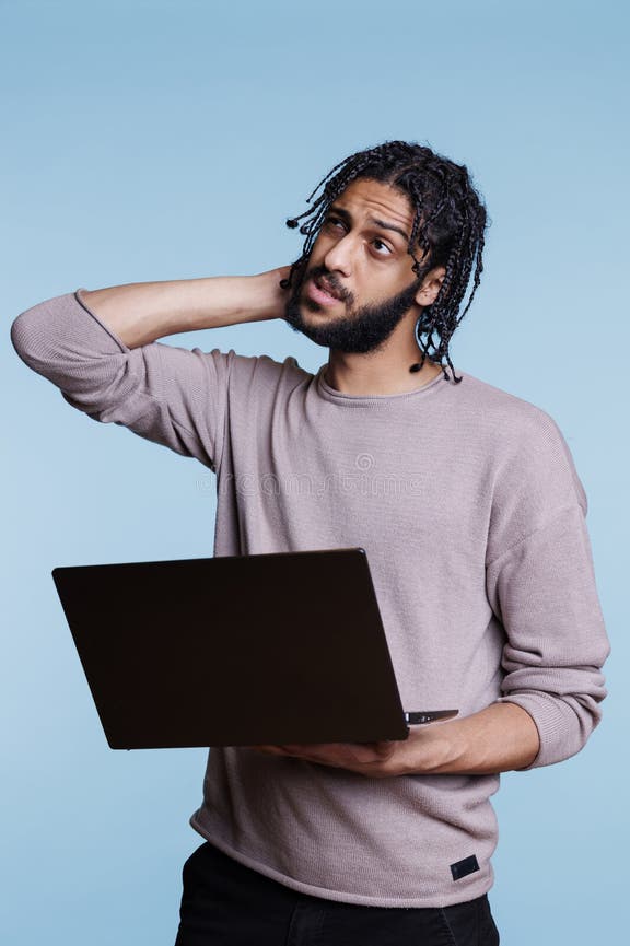 Arab Programmer Holding Laptop, Uncertain about Software App ...