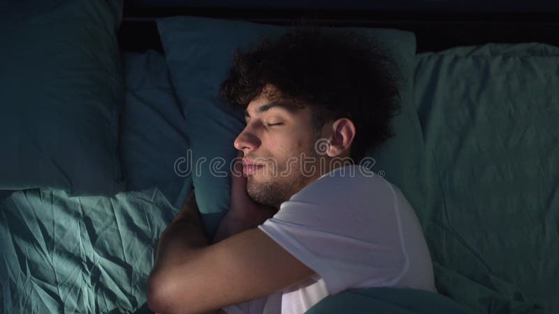 Arab Young Man Sleeping at Night in a Cozy Bed with Blue Light from the ...