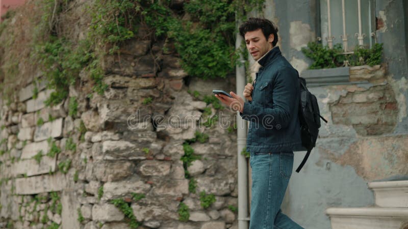 Arabian Guy with Backpack and Smartphone Walking on Street Stock ...