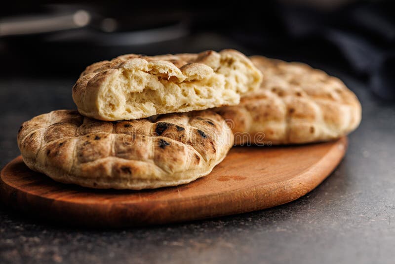 Arabic Flat Pita Bread on Cutting Board on Black Table Stock Photo ...