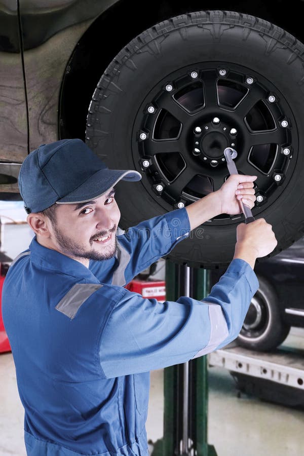Arabic Mechanic Replacing a Car Wheel Stock Photo - Image of replace ...