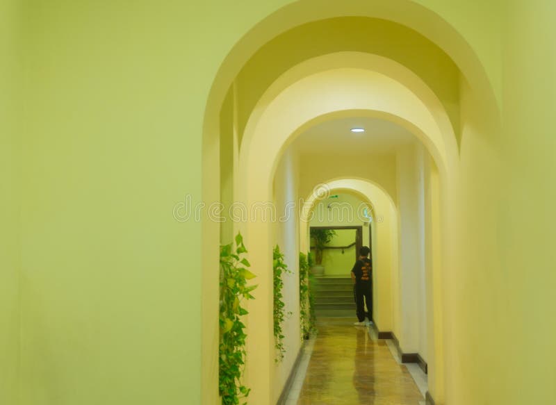 Yellow Hotel Corridor with Many Classical Arches and Decorative Vines ...
