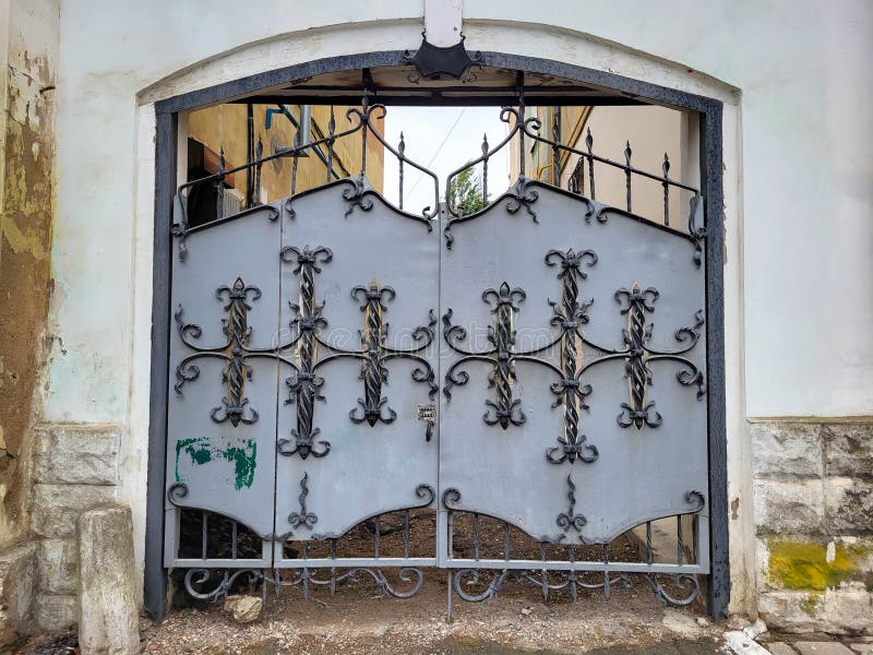 The Arch of the House Has a Grey Iron Gate with Wrought Iron Elements ...