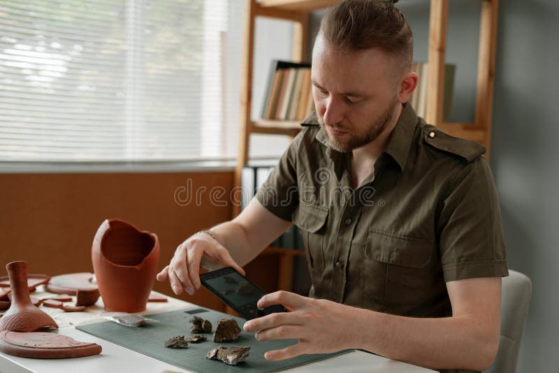 Archaeologist Working in Office Photographing Ancient Artifact Using ...