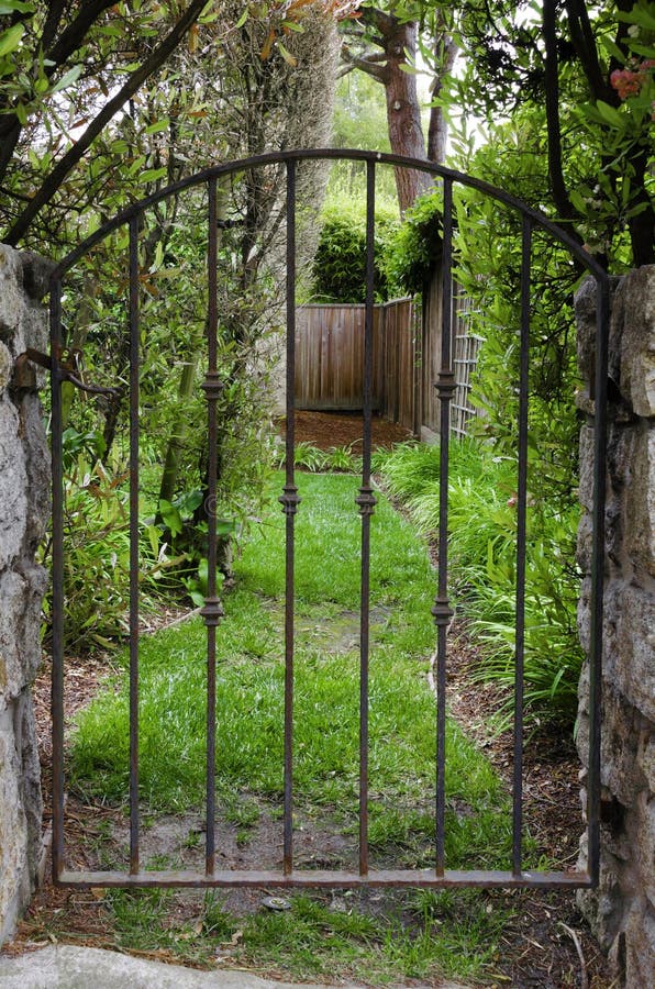An Arched Iron Gate Leading To a Backyard Garden Stock Image - Image of ...