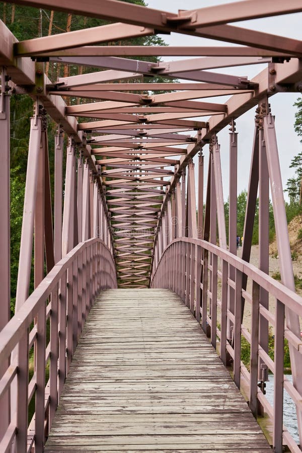An Arched Pedestrian Bridge Over the River with a Wooden Deck Stock ...