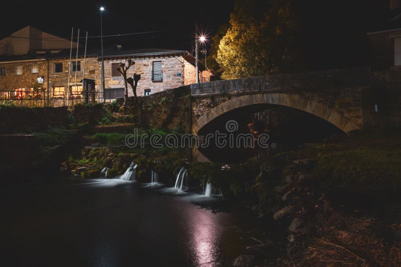 Arched Stone Bridge Over a Creek beside a Brick House at Night Stock ...
