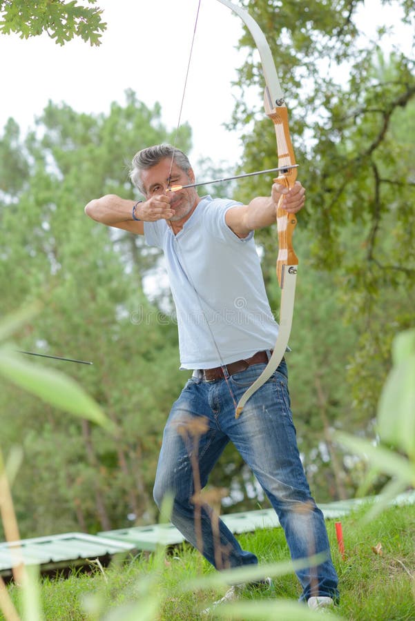 Archery Man Shooting Arrow with Bow in Nature Stock Photo - Image of ...