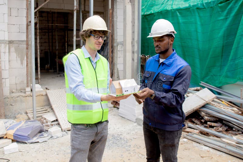Architect and Builder Talking and Holding Model House at Construction ...