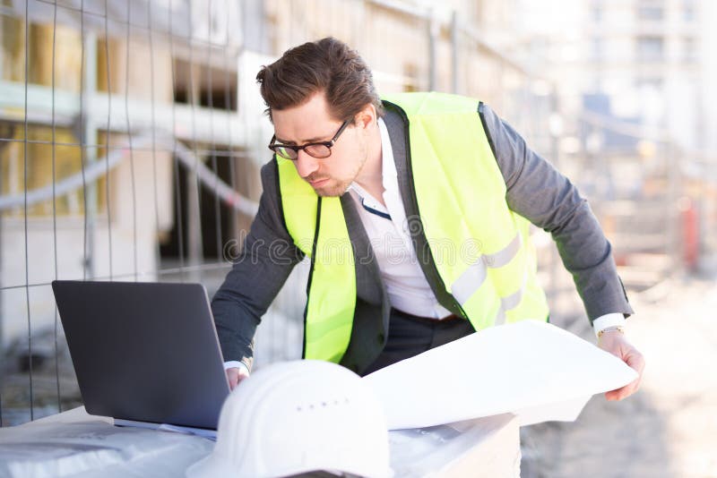 An Architect / Civil Engineer at Work on a Construction Site, Holding ...