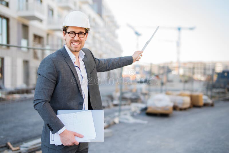 An Architect / Civil Engineer at Work on a Construction Site, Holding ...