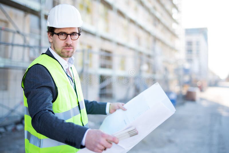 An Architect / Civil Engineer at Work on a Construction Site, Holding ...