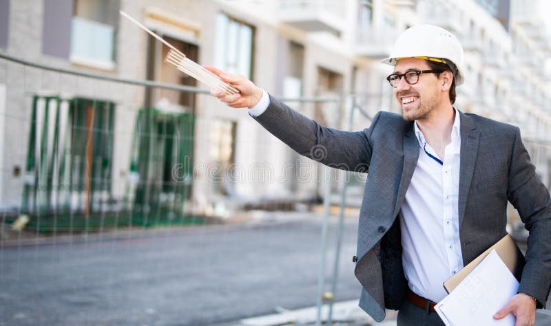 An Architect / Civil Engineer at Work on a Construction Site, Holding ...